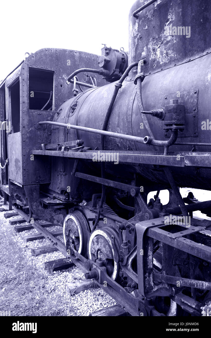 Closeup of antique rusty broken steam locomotive standing on rails ...
