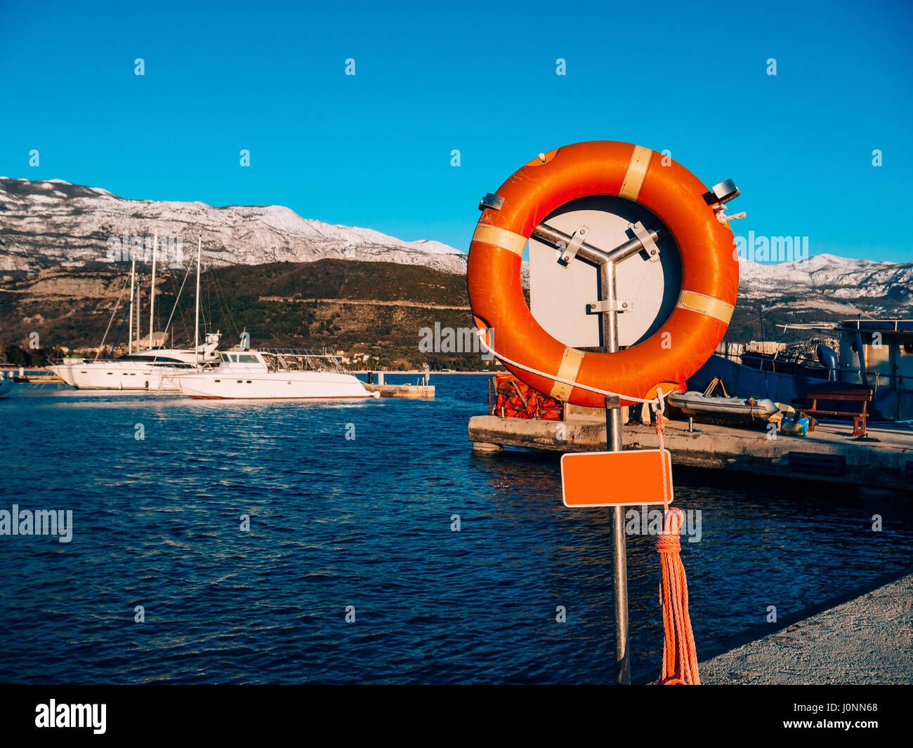 Lifebuoy in the marina for yachts. Red circle on the boat dock. Porto ...