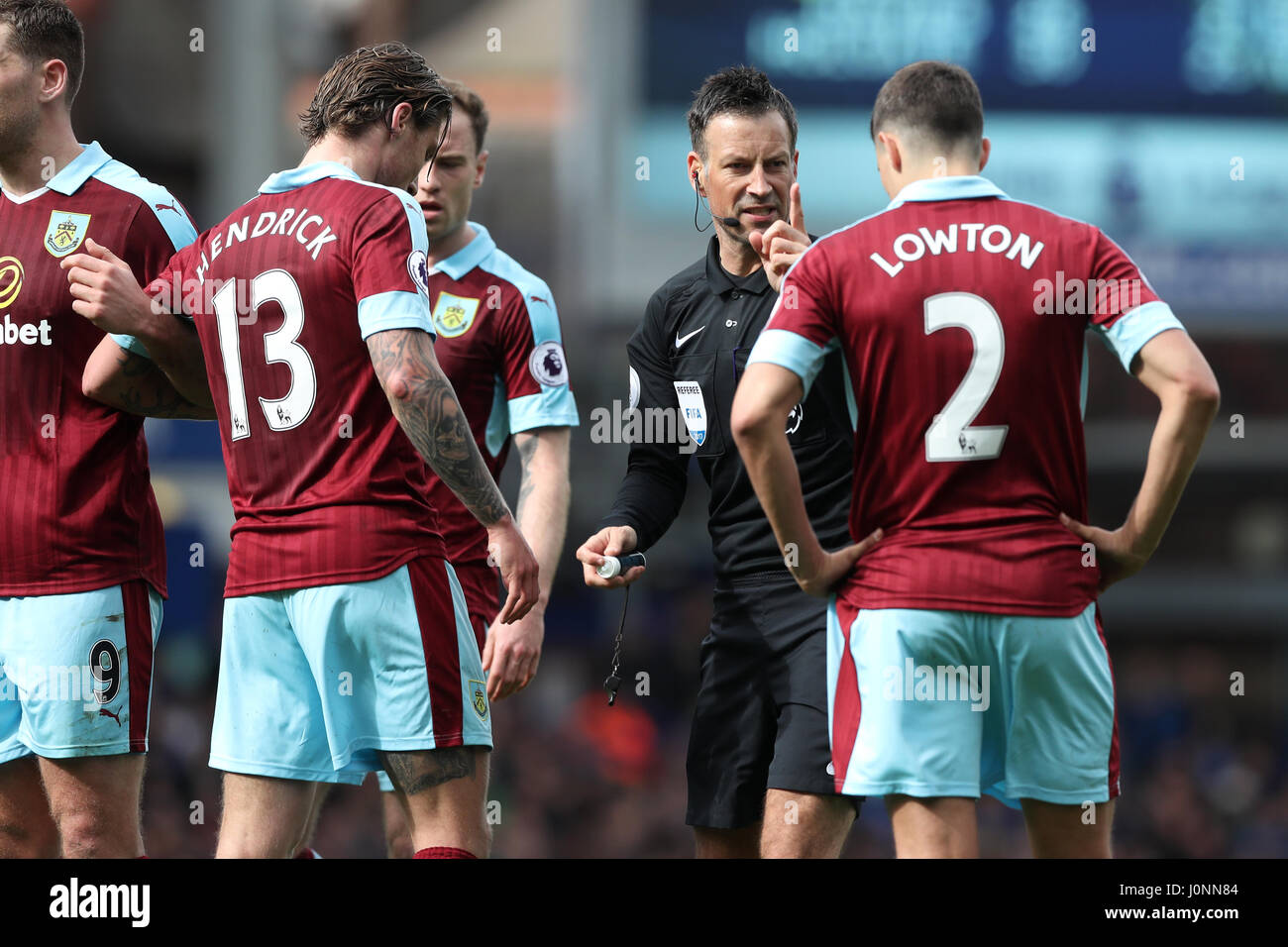 Referee Mark Clattenburg (centre) lectures Burnley's Matthew Lowton ...