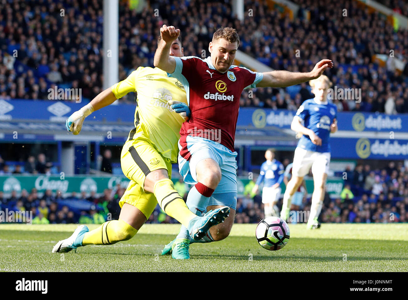 Burnley's Sam Vokes (right) is brought down by Everton goalkeeper Joel ...