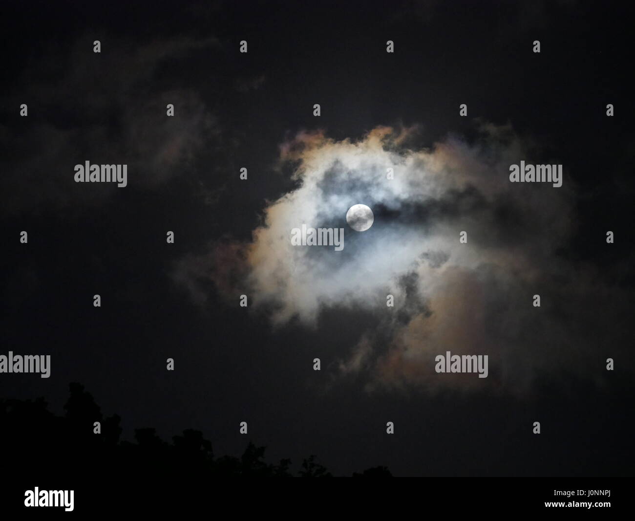 Clouds around a full moon Clouds form around the moon creating a spooky ...