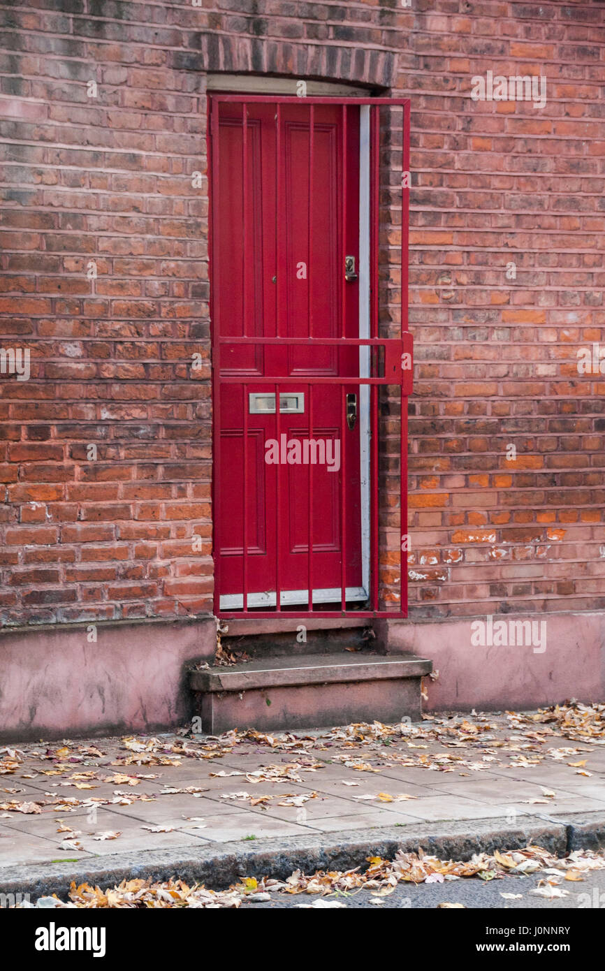 Red door with security gate Stock Photo - Alamy