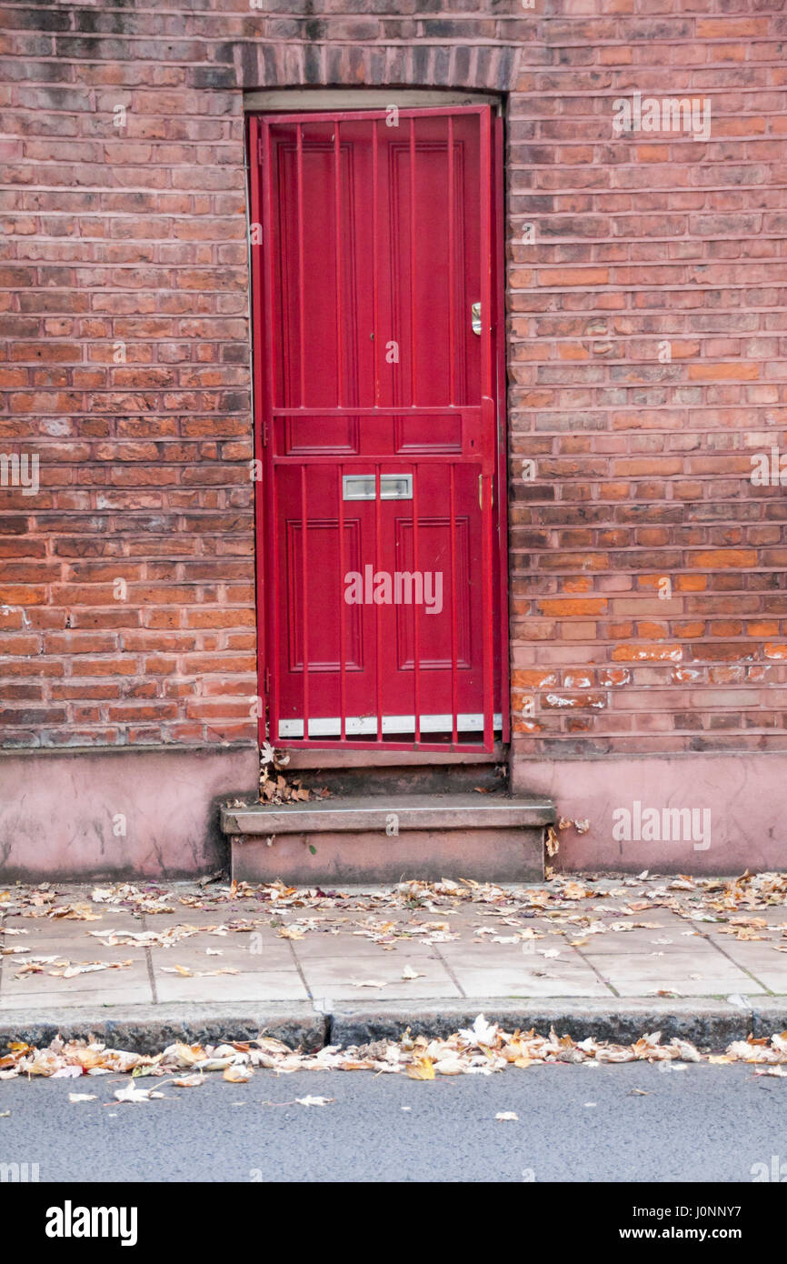 Red door with security gate Stock Photo - Alamy