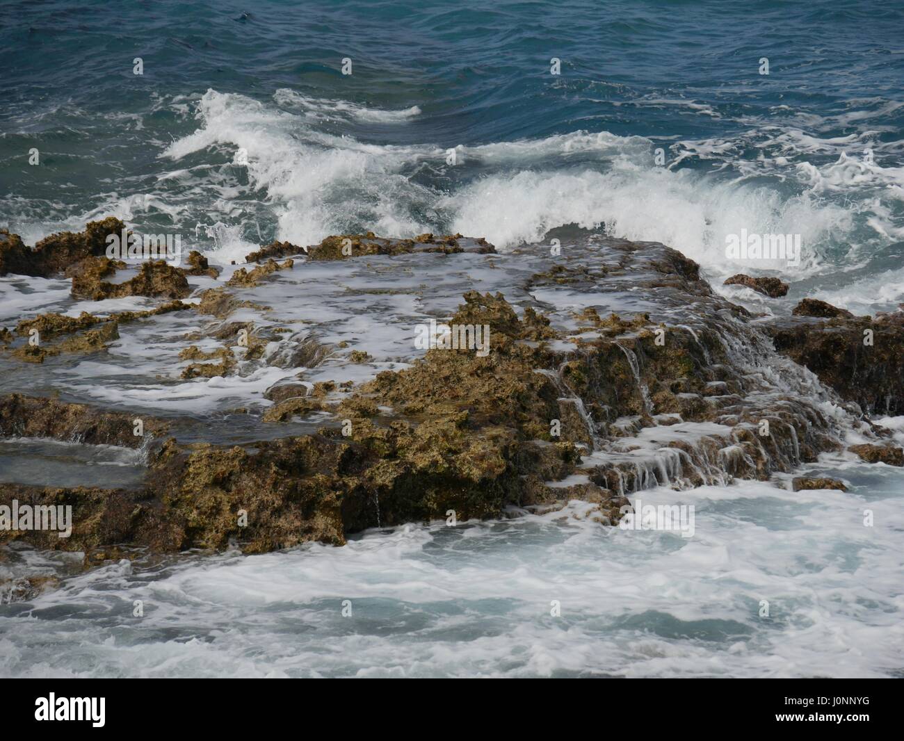 Crashing waves on rocks foams of water crash against the sharp rocks ...