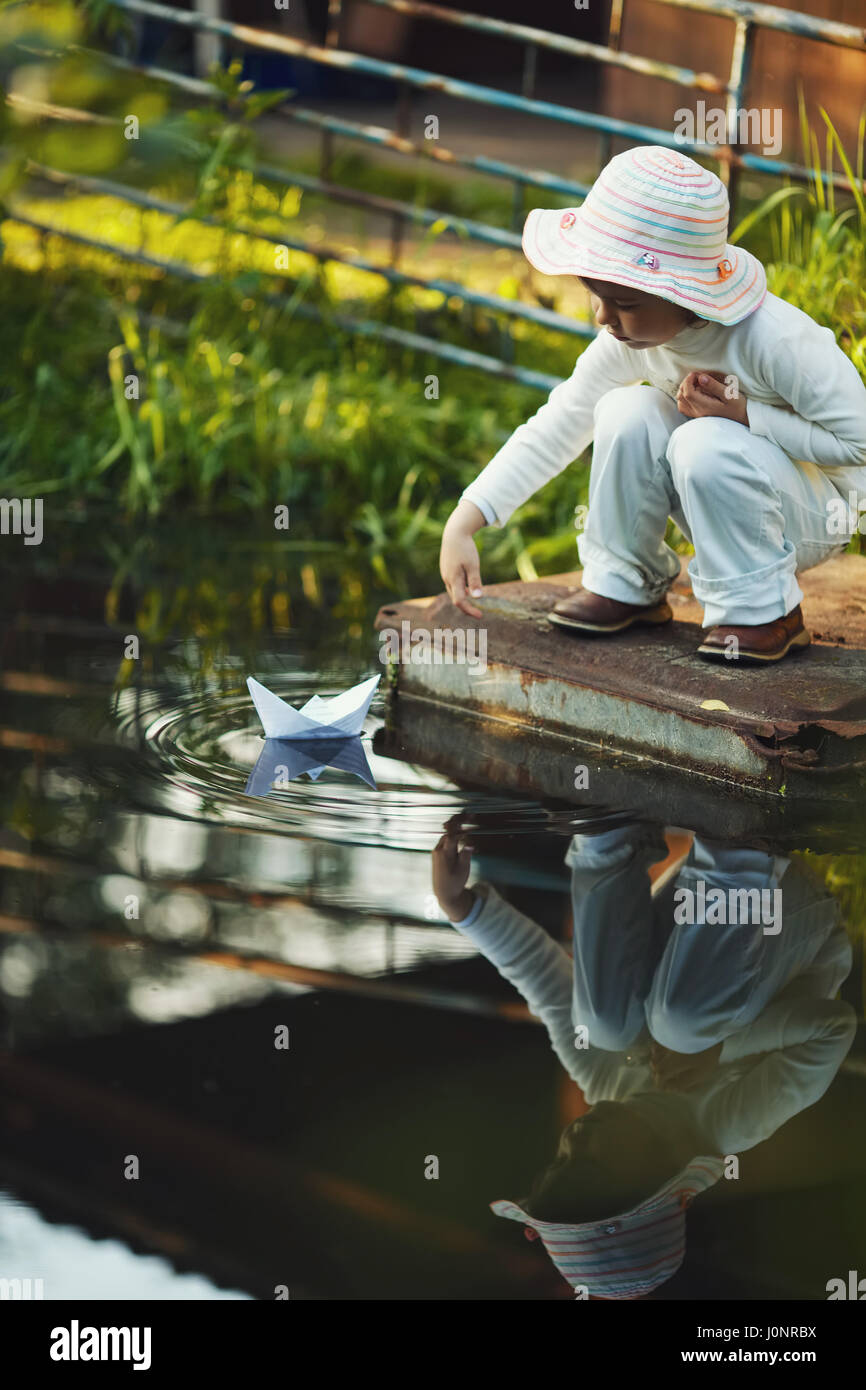girl plays with paper boat in the river Stock Photo - Alamy