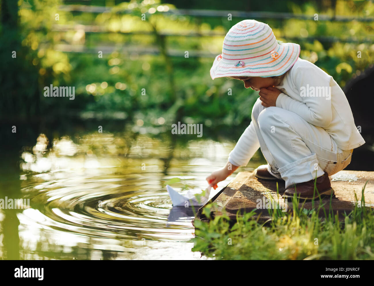 girl plays with paper boat in the river Stock Photo - Alamy