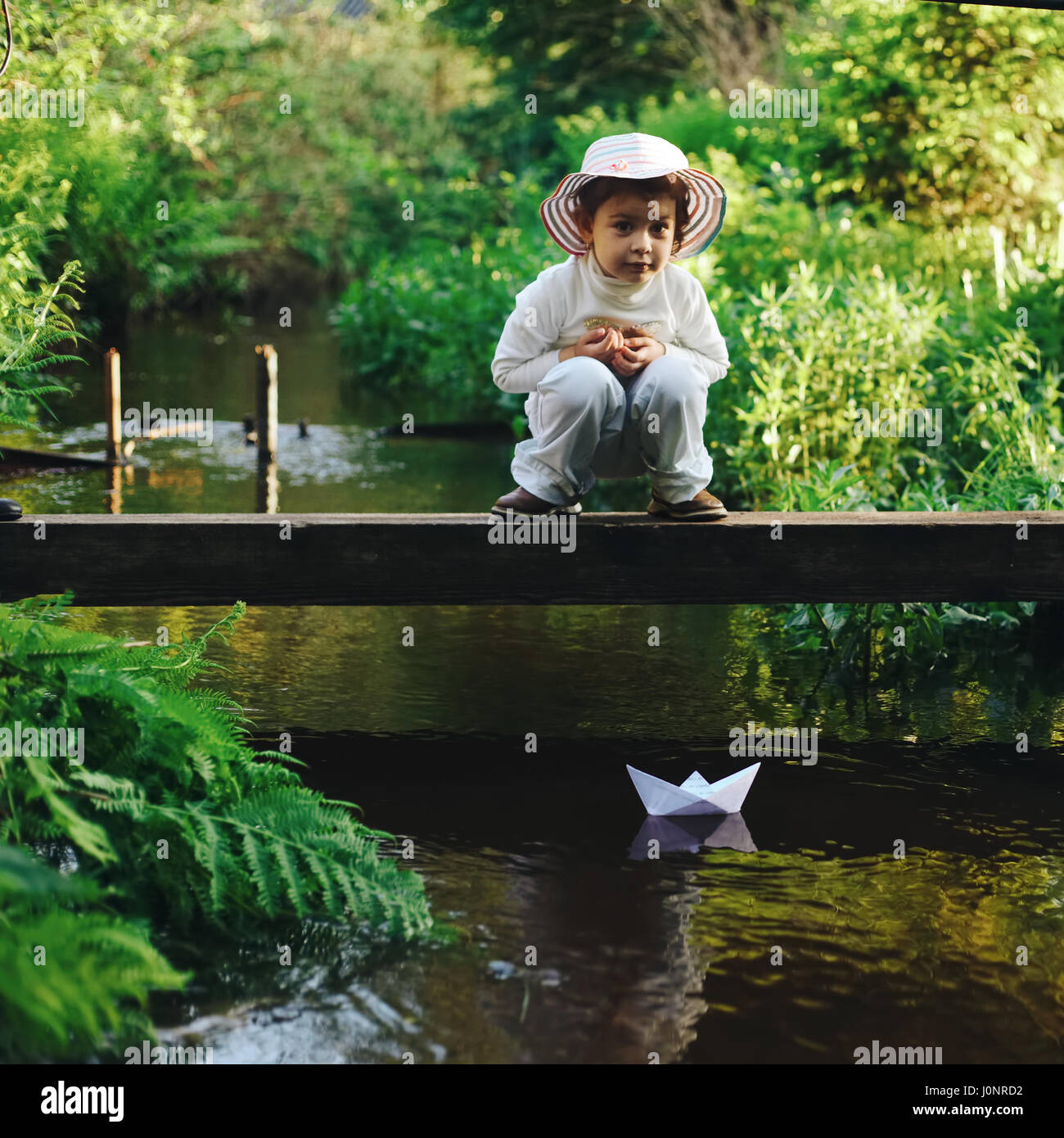 girl plays with paper boat in the river Stock Photo - Alamy