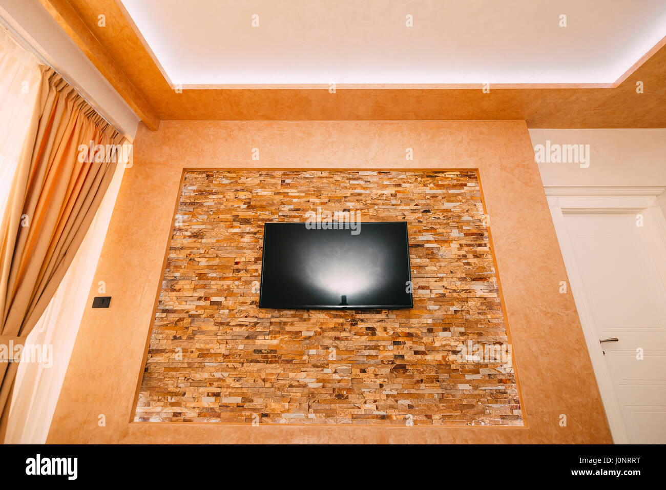 TV on the wall. TV hanging on the wall in the apartment Stock Photo - Alamy