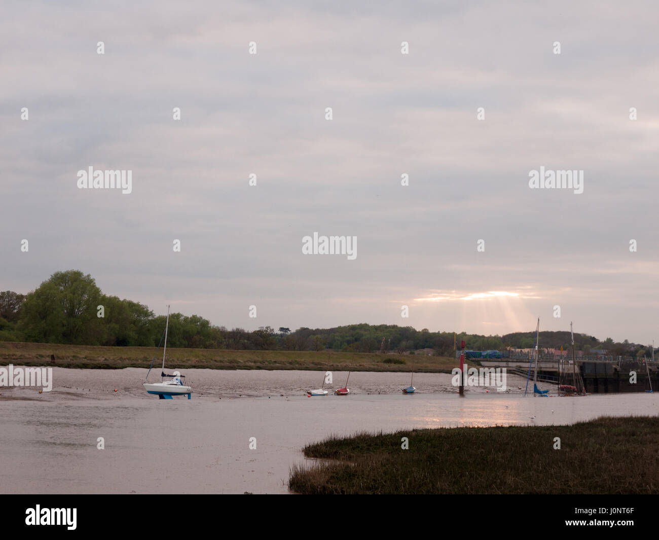 Moored boats and yachts at low tide on Wivenhoe Estuary in Essex ...