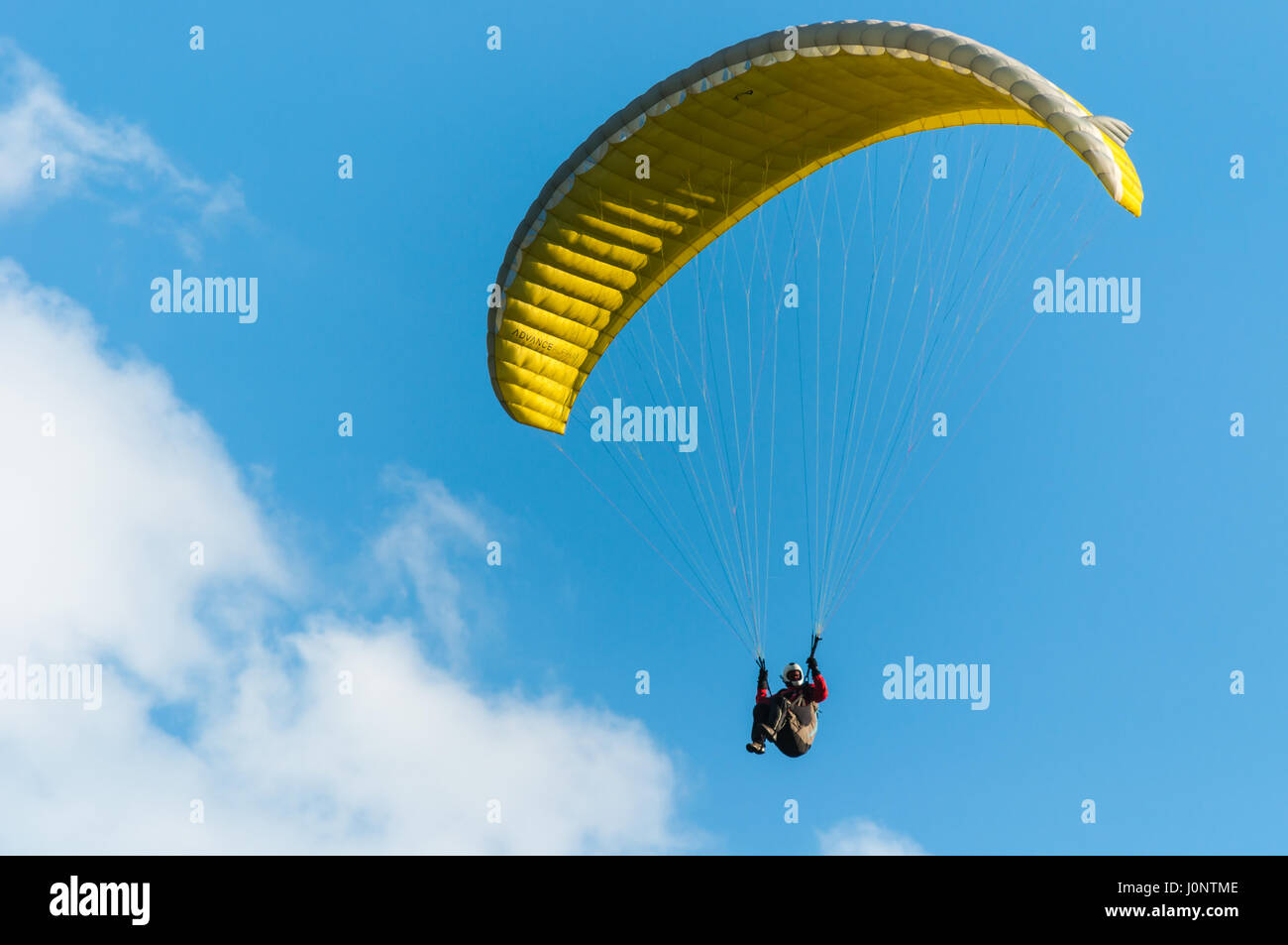 Paraglider fly in the blue sky between clouds and over the mountains ...
