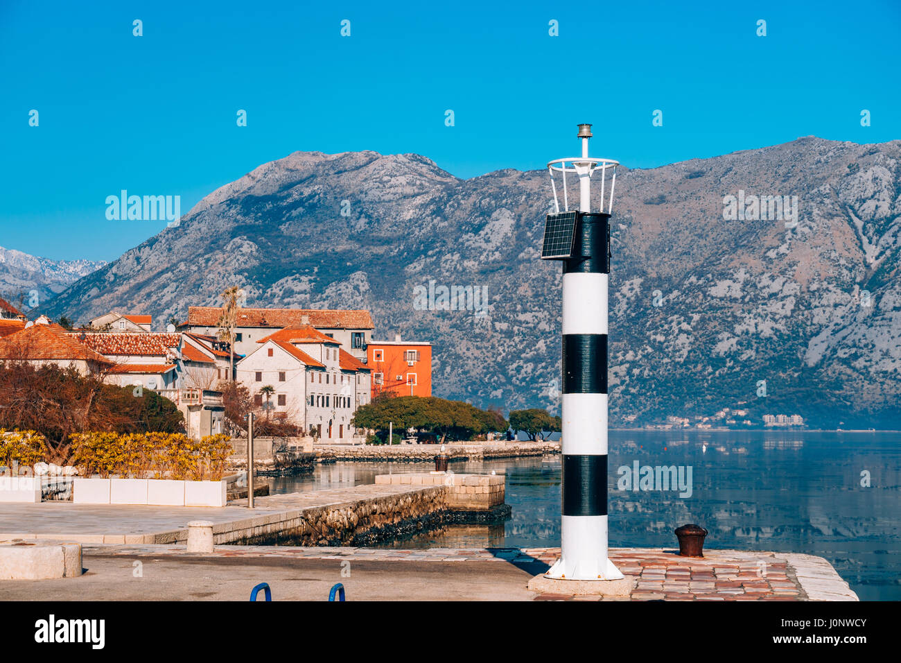 Black and white lighthouse in the sea. Prcanj, Kotor Bay, Montenegro ...
