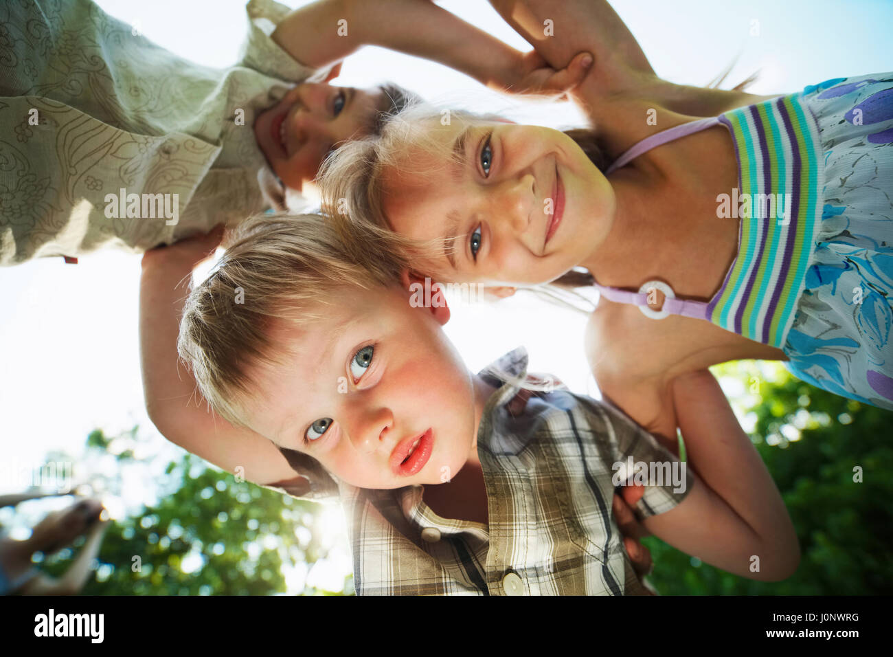 happy children hugging bottom view Stock Photo - Alamy