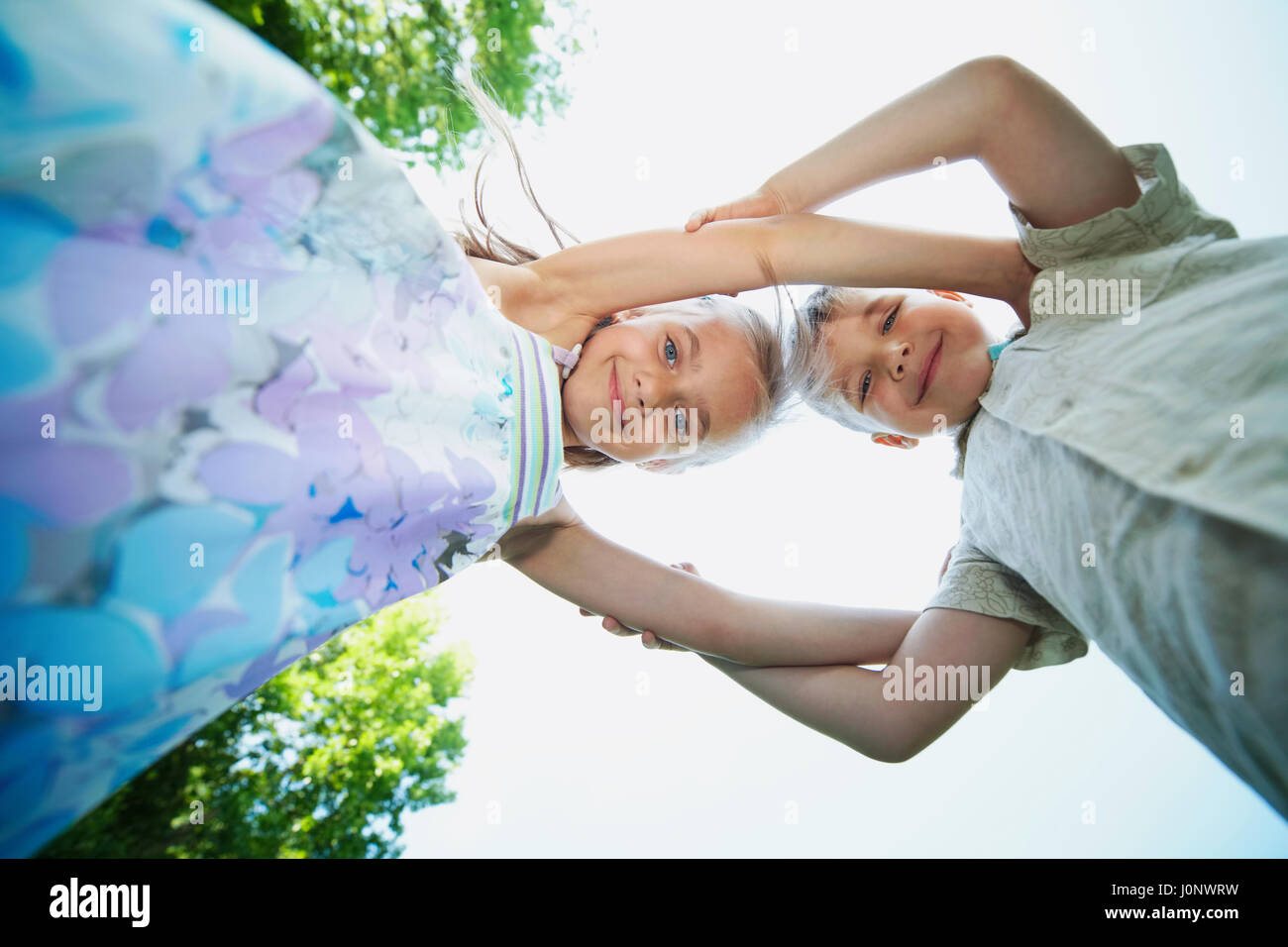 happy children hugging bottom view Stock Photo - Alamy
