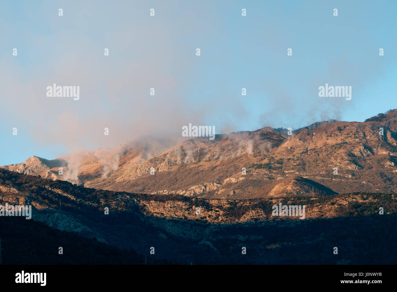 Fire in the mountains in the afternoon. Smoke over the mountains. Budva ...