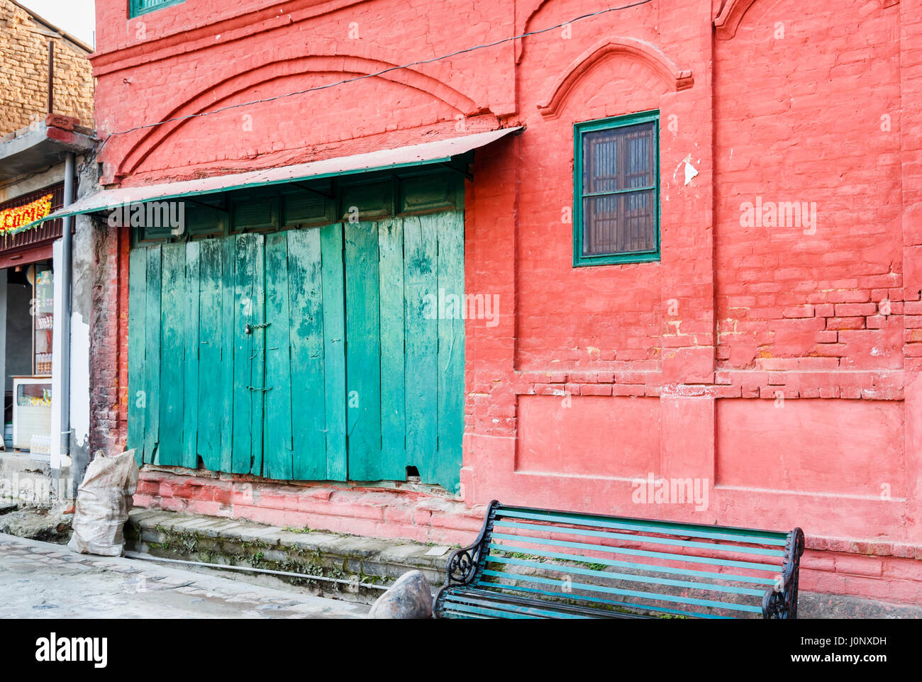Painted red brick warehouse building with green dilapidated wooden ...
