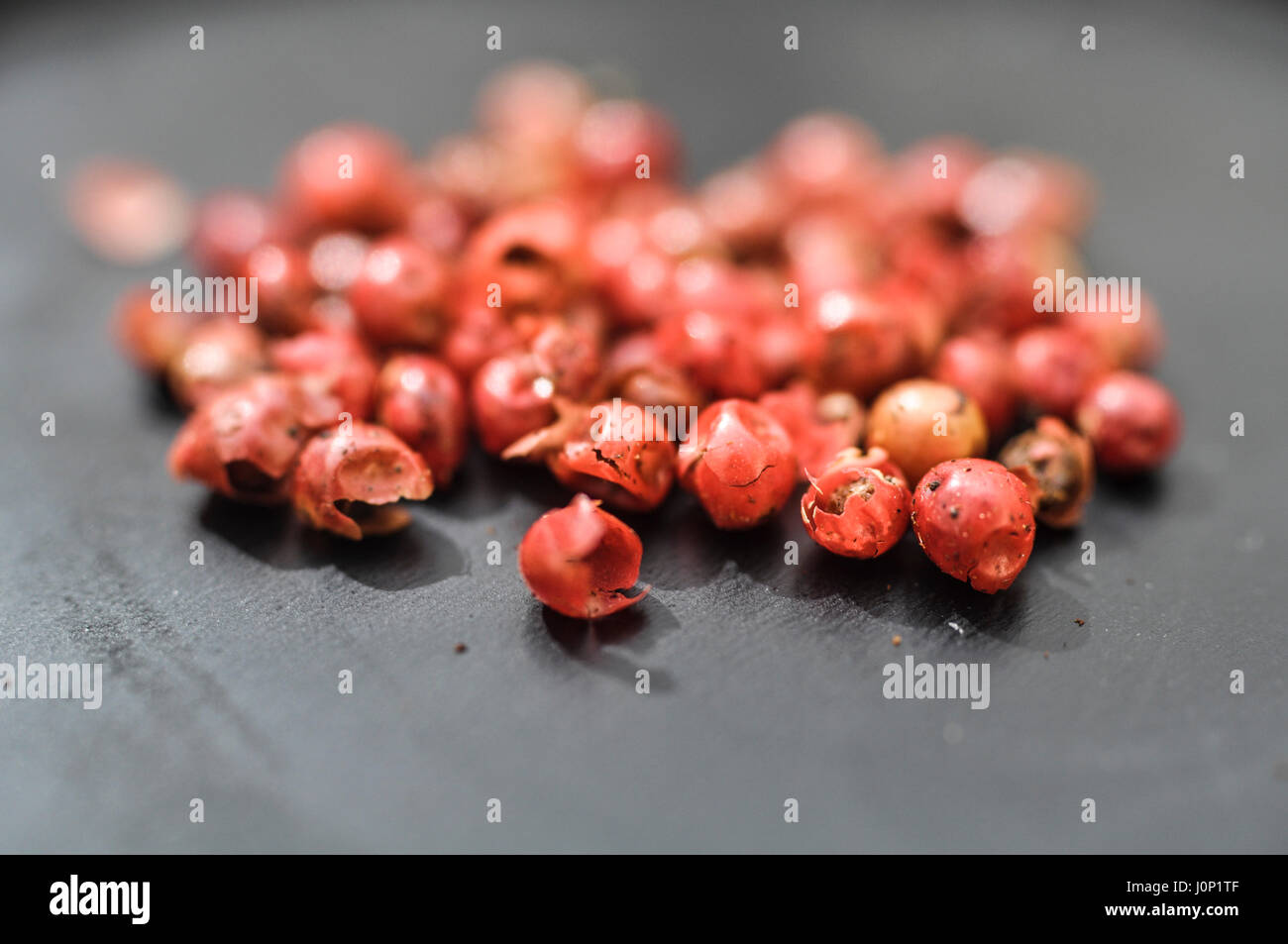 Pink Pepper on Black Background Stock Photo - Alamy