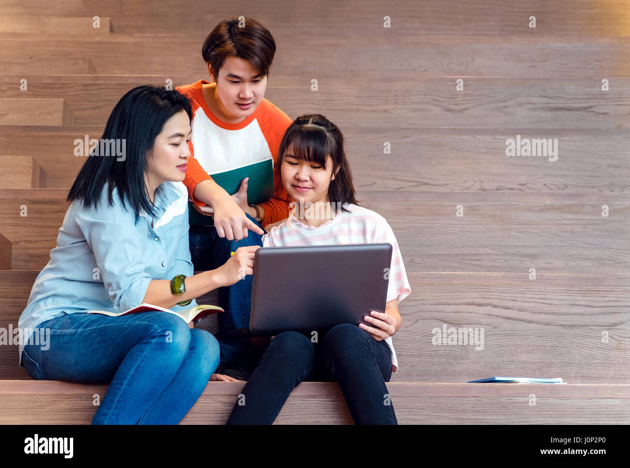 Groups of asian teenage students using laptop computer studying ...
