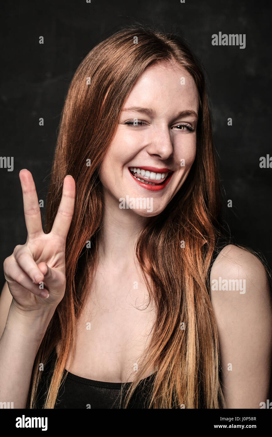 Young woman showing peace sign Stock Photo - Alamy