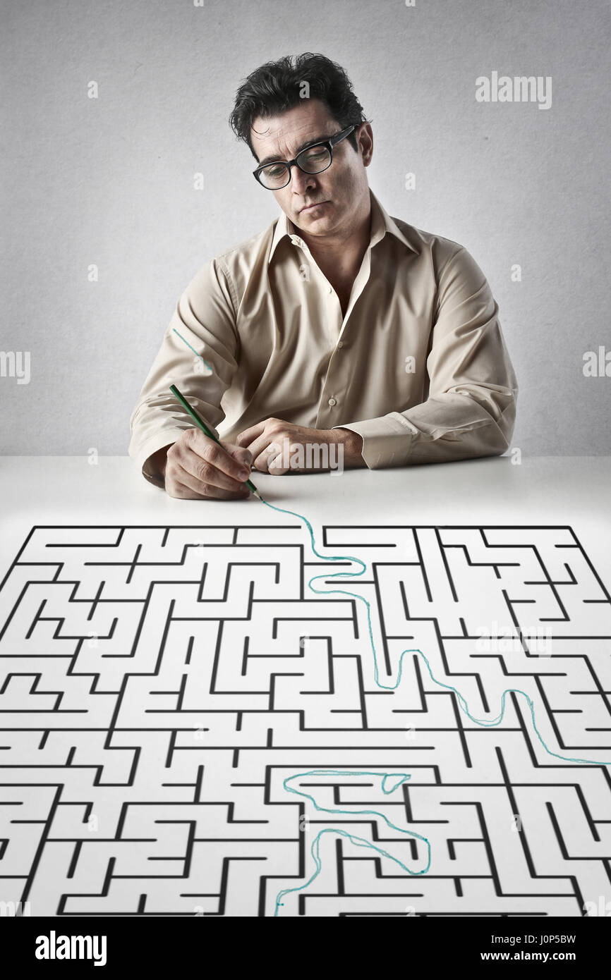 Businessman solving labyrinth Stock Photo - Alamy