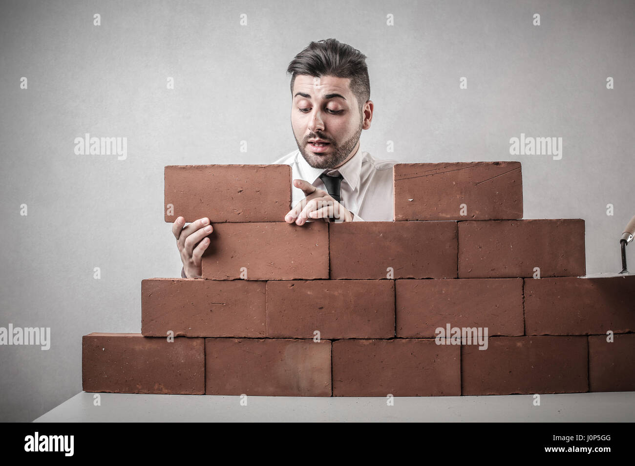 Businessman building wall Stock Photo - Alamy