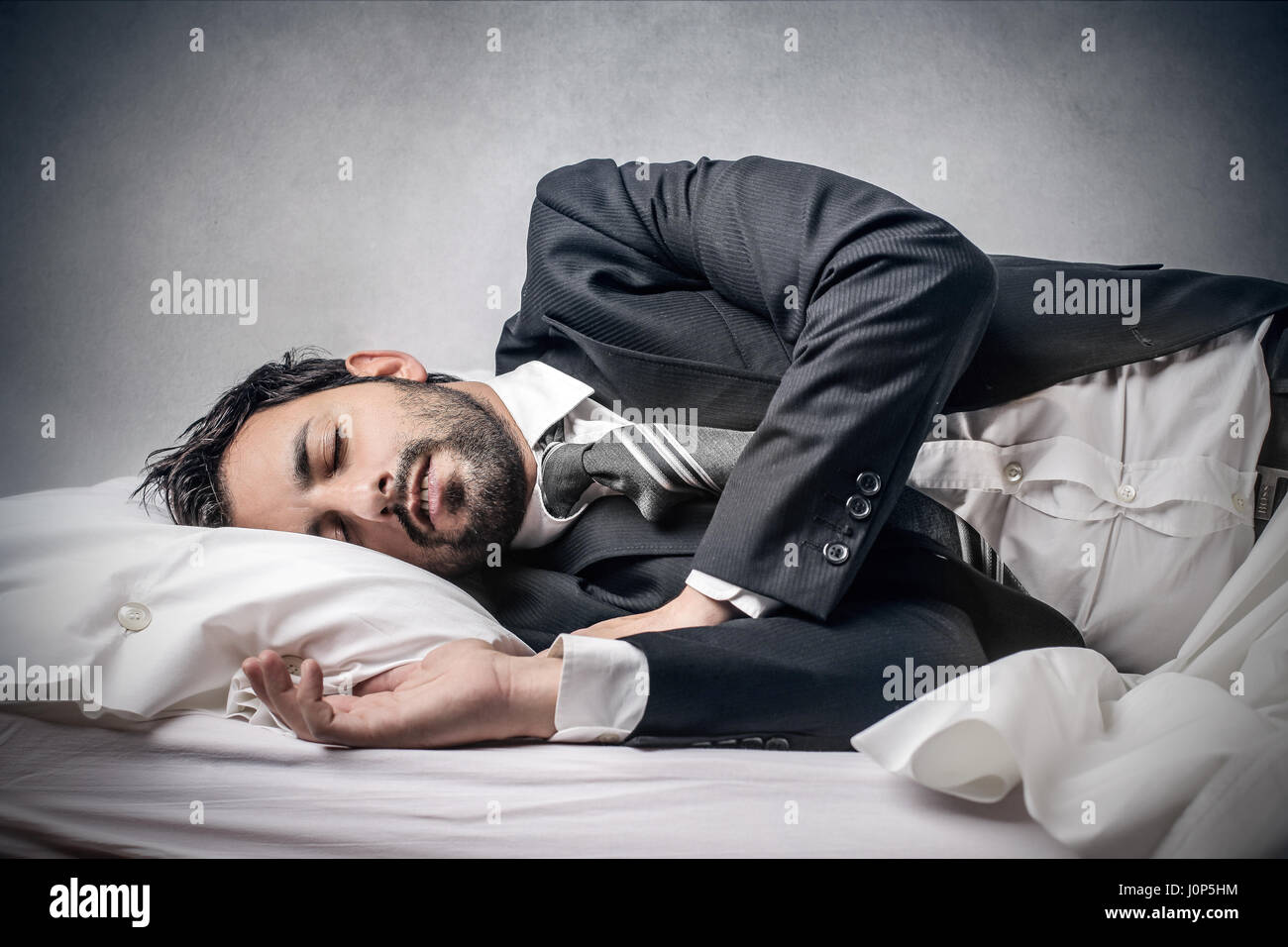 Businessman sleeping on bed Stock Photo - Alamy