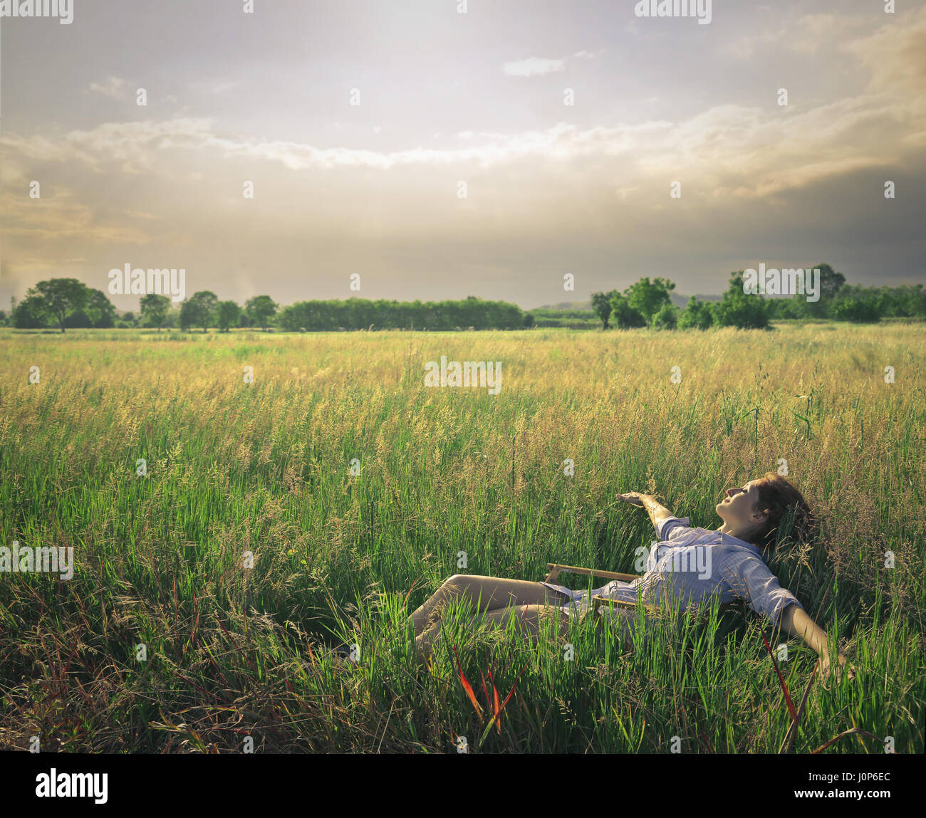 Woman laying on field Stock Photo - Alamy