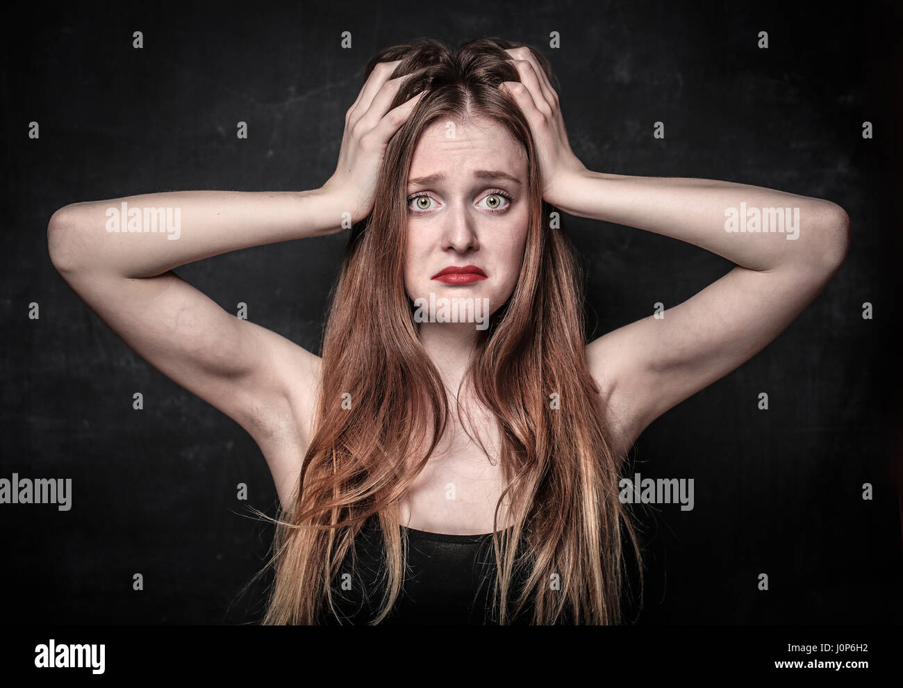 Young woman being worried and holding her head Stock Photo - Alamy
