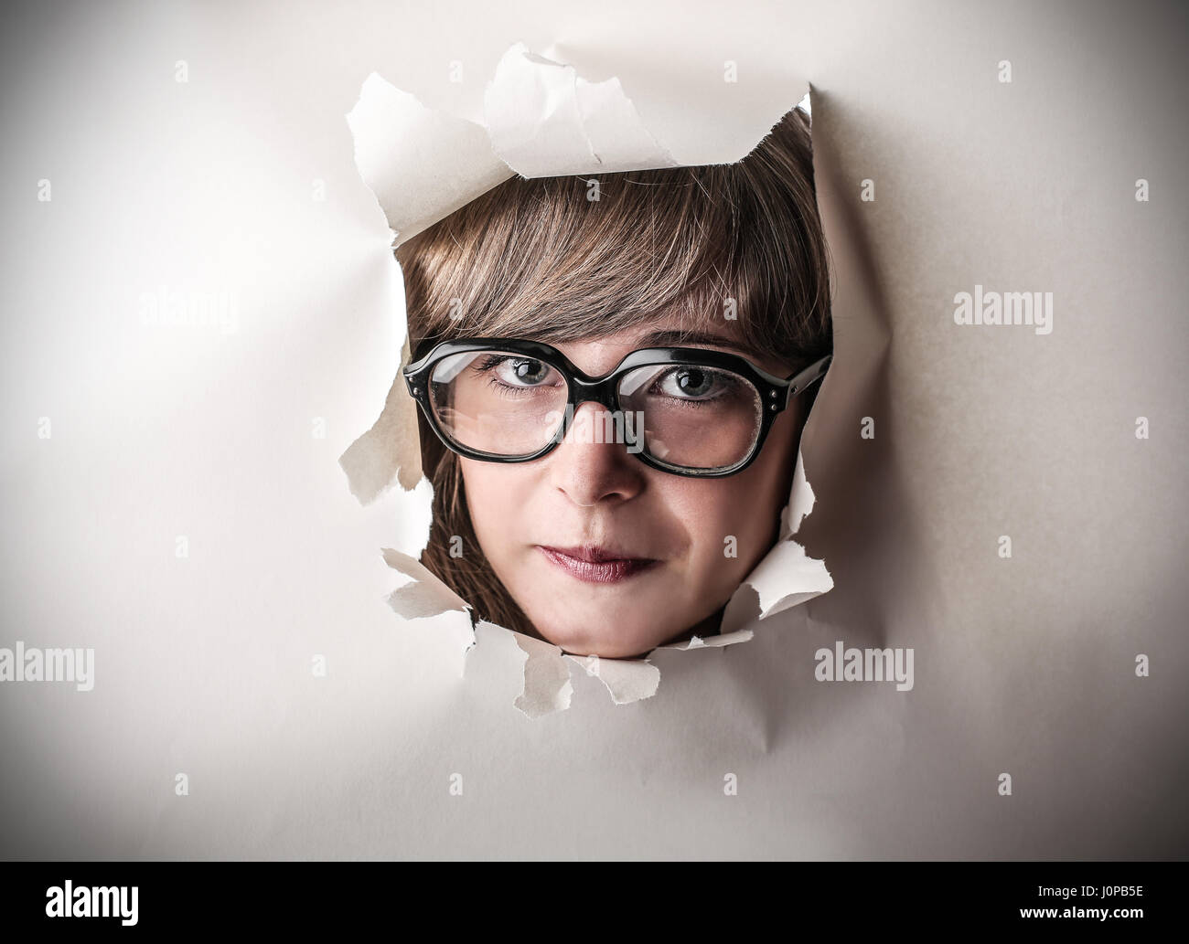 Young woman breaking through paper Stock Photo - Alamy