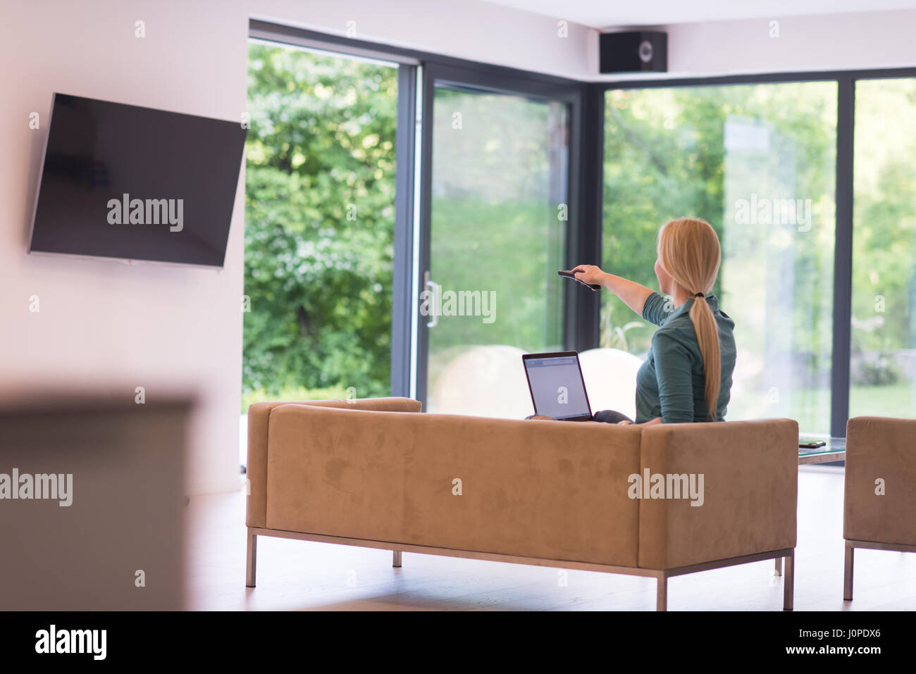 Young woman using her laptop computer in her luxury modern home ...
