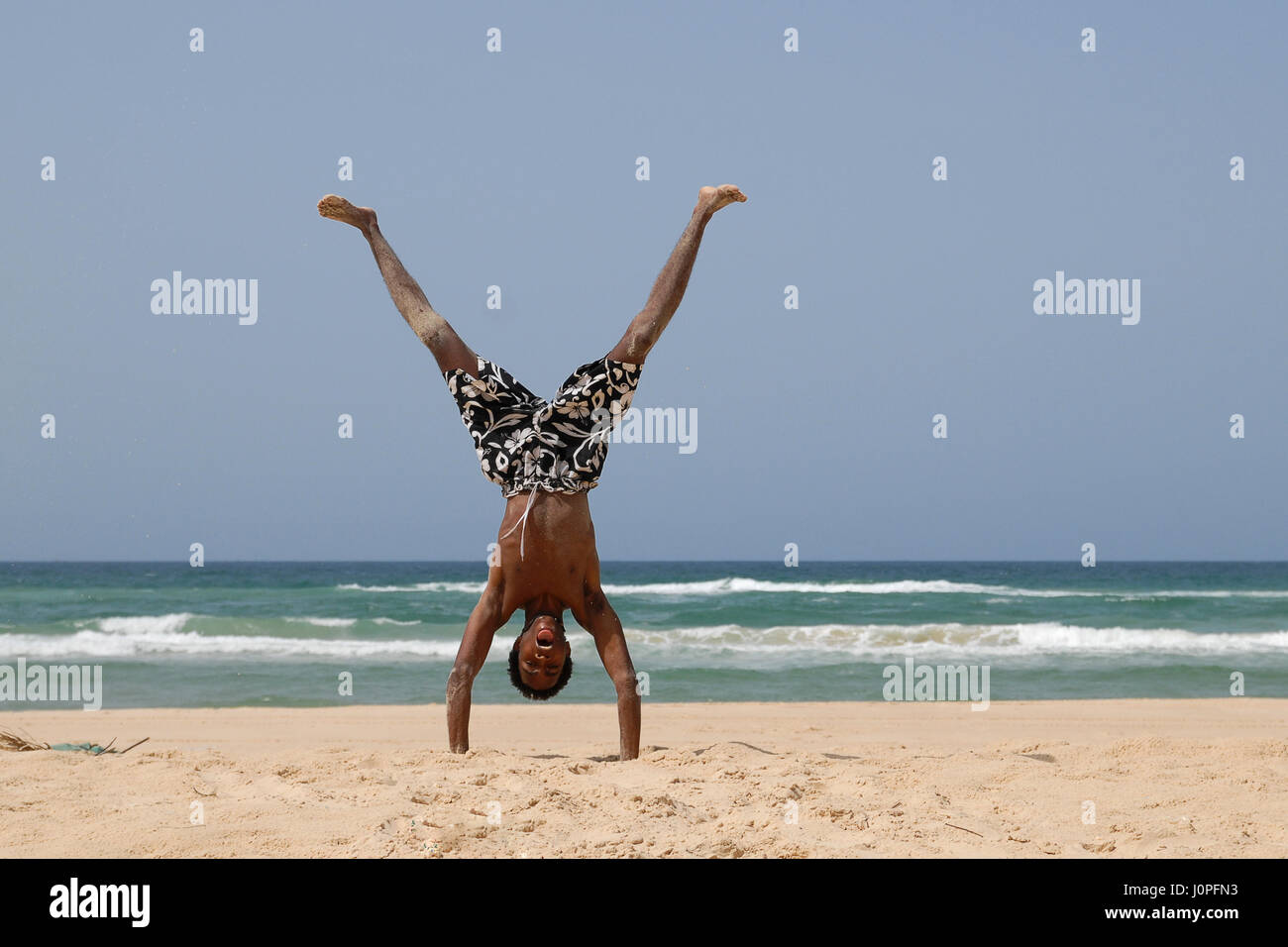 African young man doing handstanding on the beach Stock Photo - Alamy