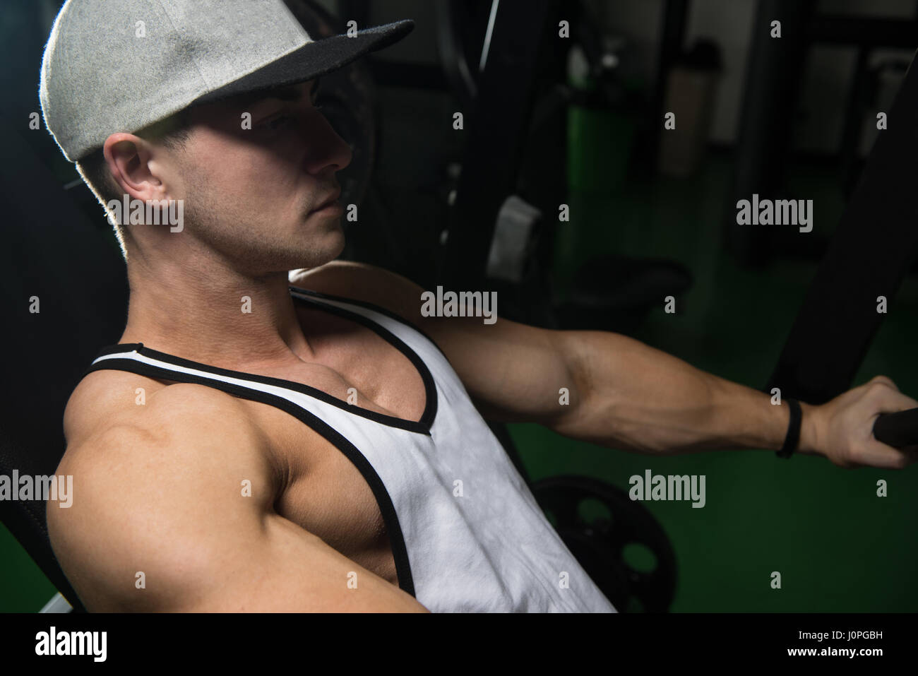 Young Strong Man In The Gym And Exercising Chest On Machine - Muscular ...