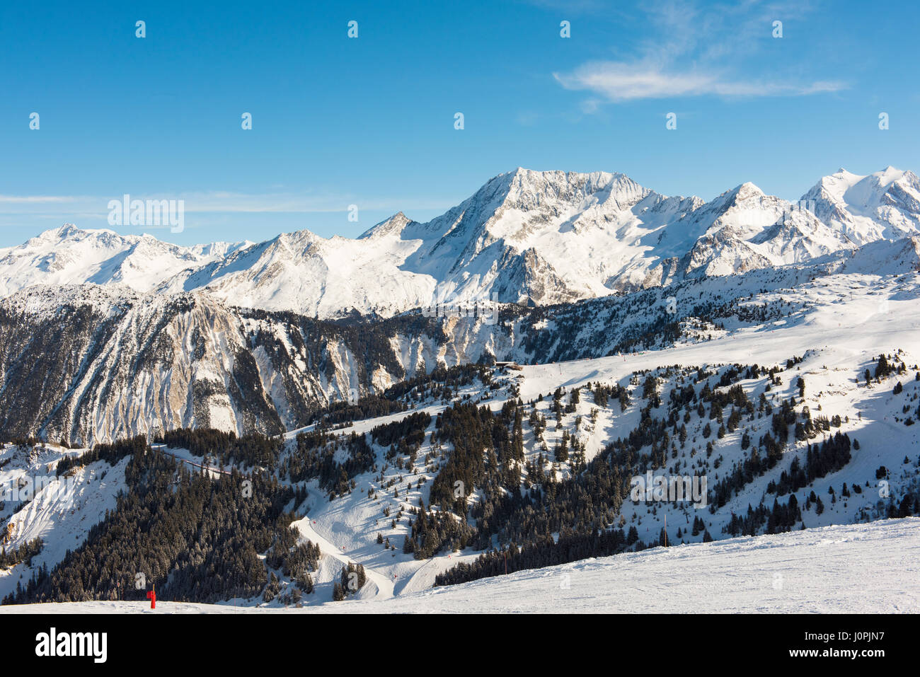 Panoramic view down snow covered valley in alpine mountain range with ...