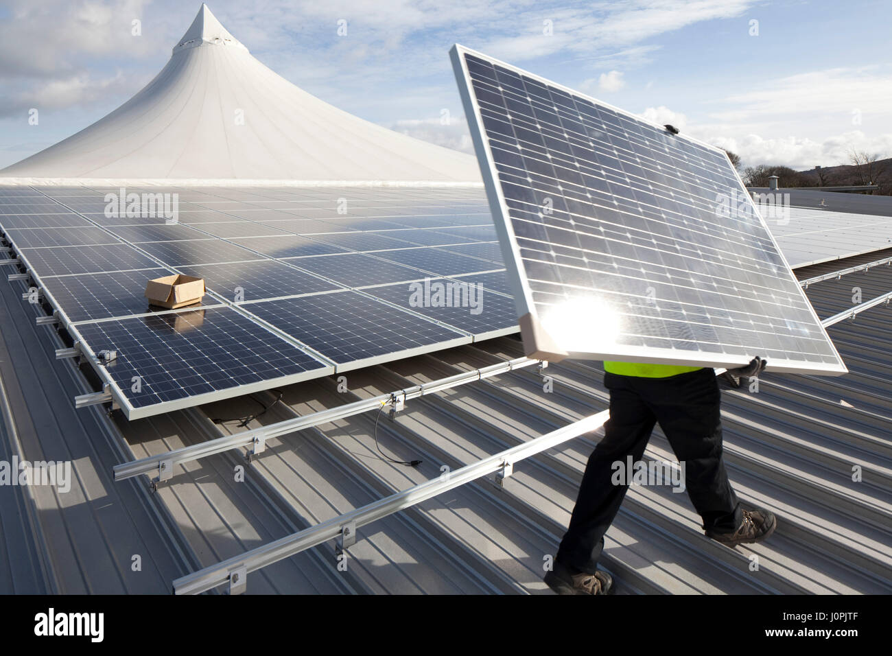 Solar pv being installed onto the roof of Truro college Stock Photo - Alamy