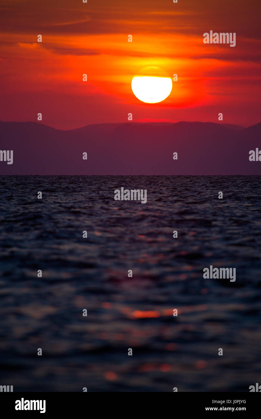 A blood red sunset over a mountain range and the Great Barrier Reef ...