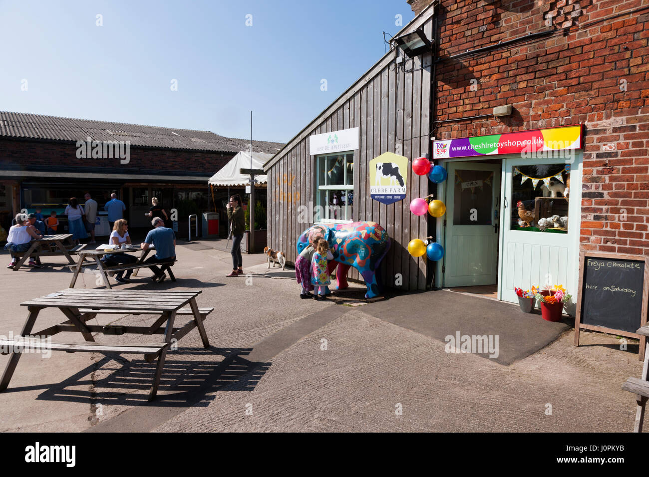 Farm shop entrance and farm yard with tables for visitors on a sunny ...
