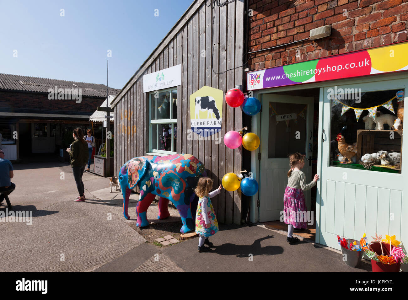 Farm shop entrance and farm yard with tables for visitors on a sunny ...