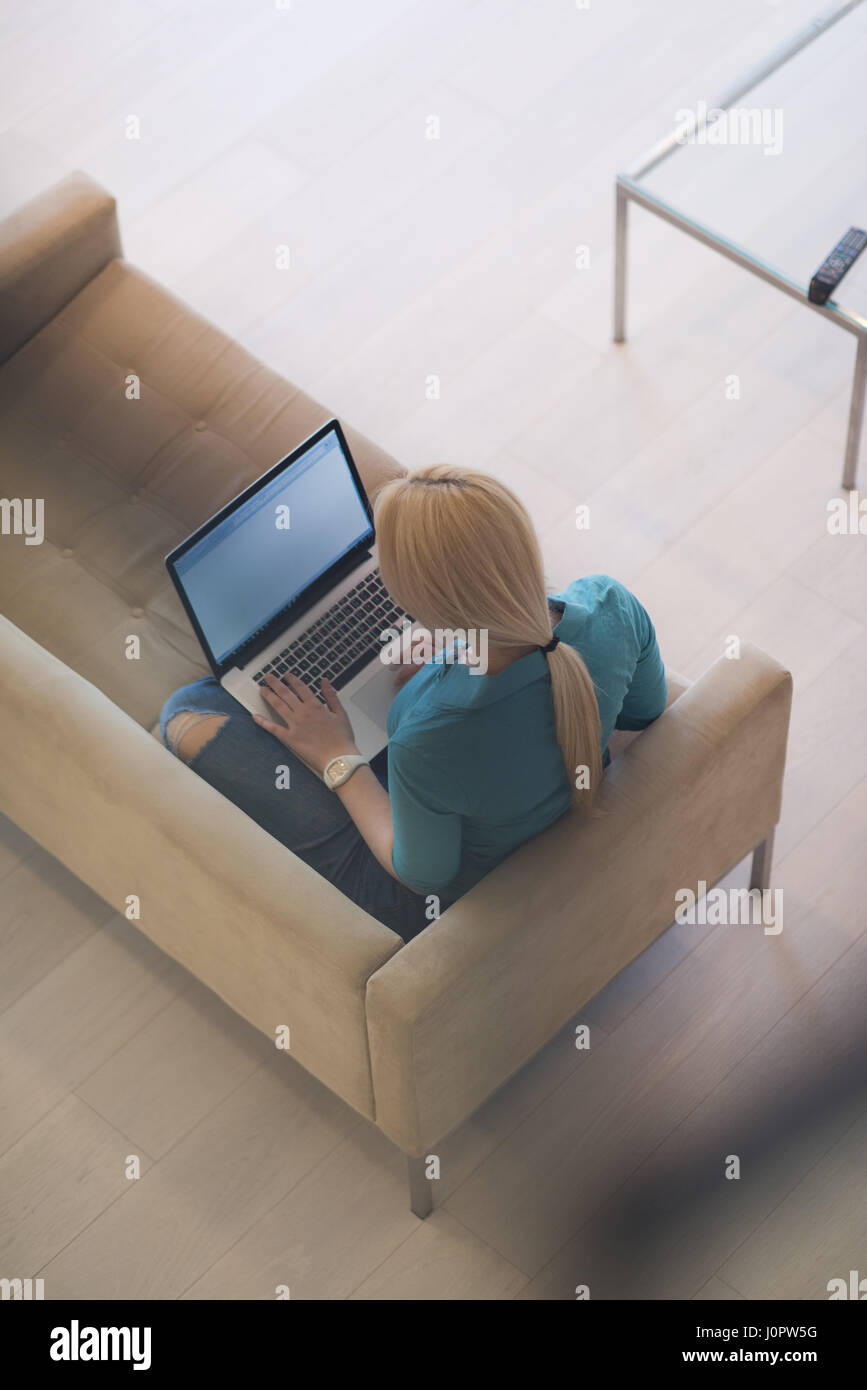 Young woman using her laptop computer in her luxury modern home ...