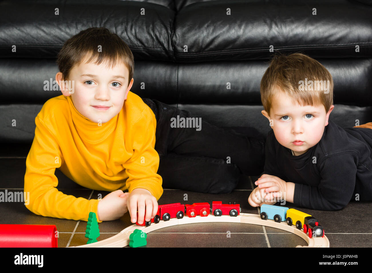 Children playing with wooden toy train. Brothers build wooden railroad ...
