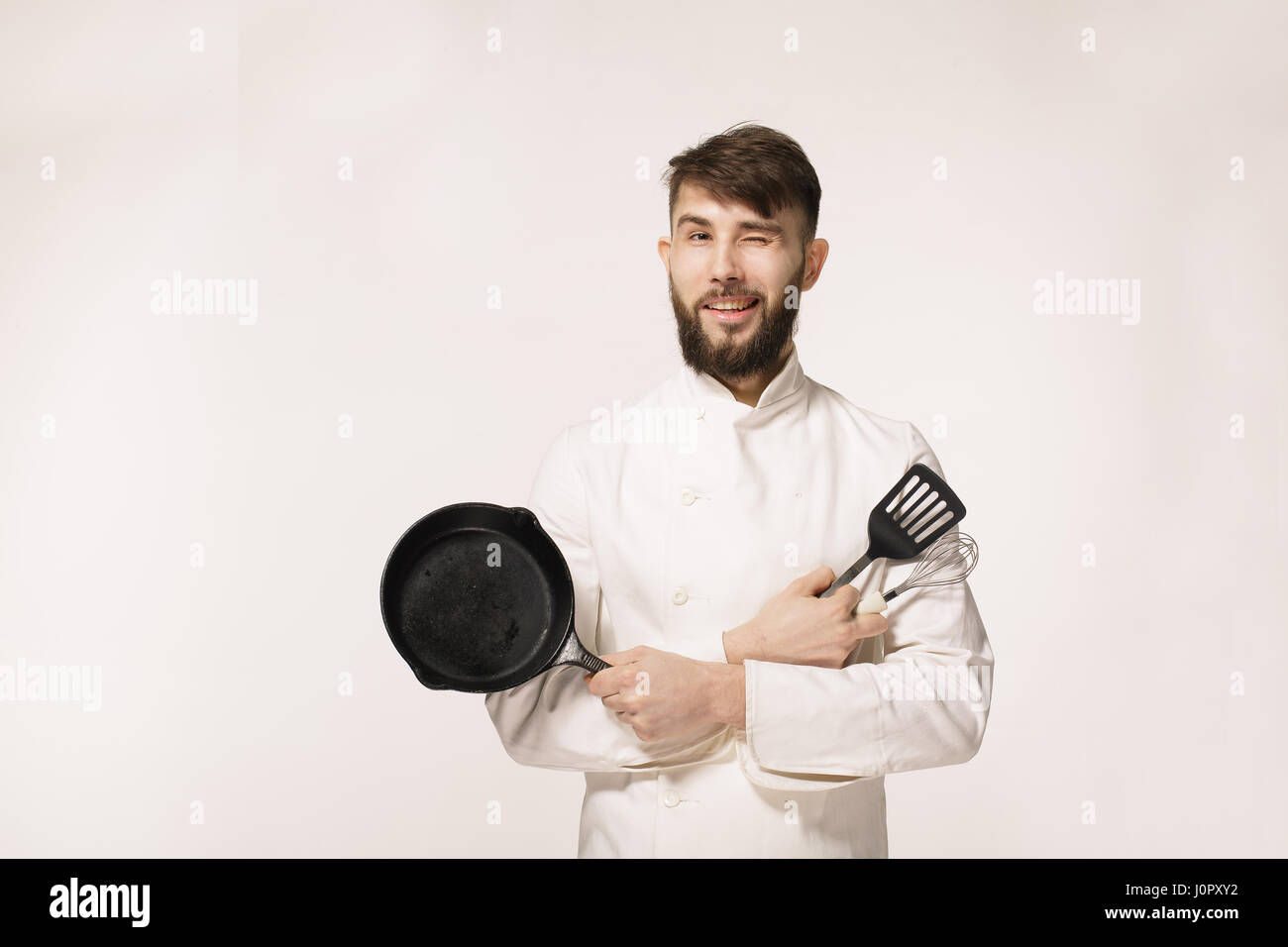 Confident chef. Cheerful young African chef in white uniform keeping ...