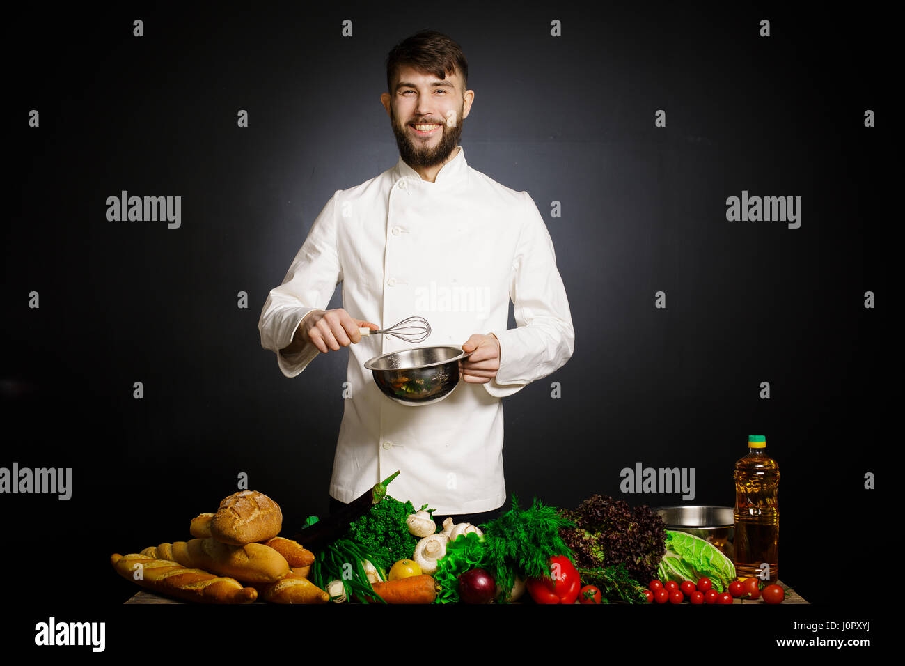 Cook chef with vegetables splah and black dark background. Food musical ...