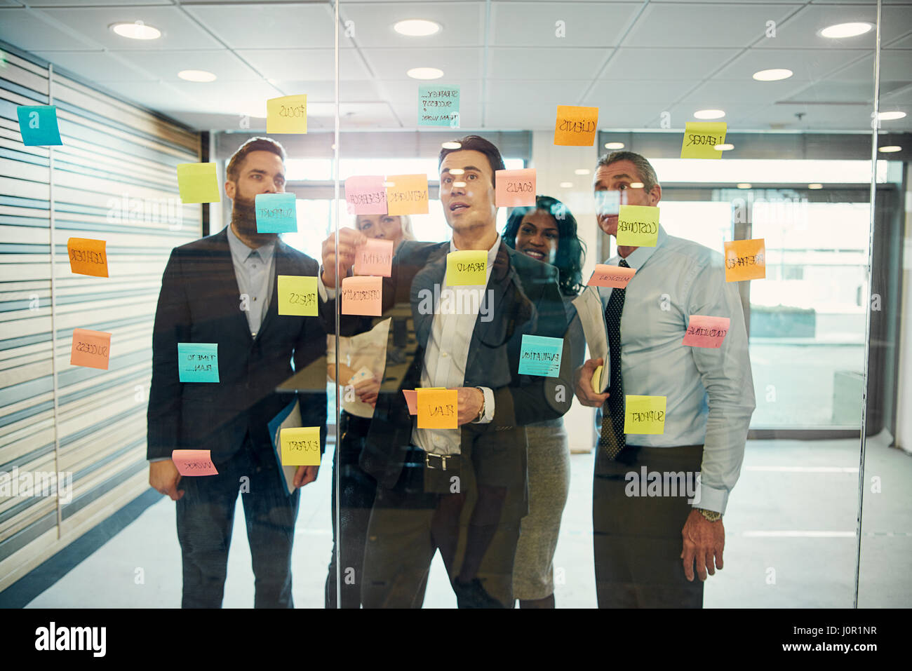 The people standing at the transparent wall with stickers and ...