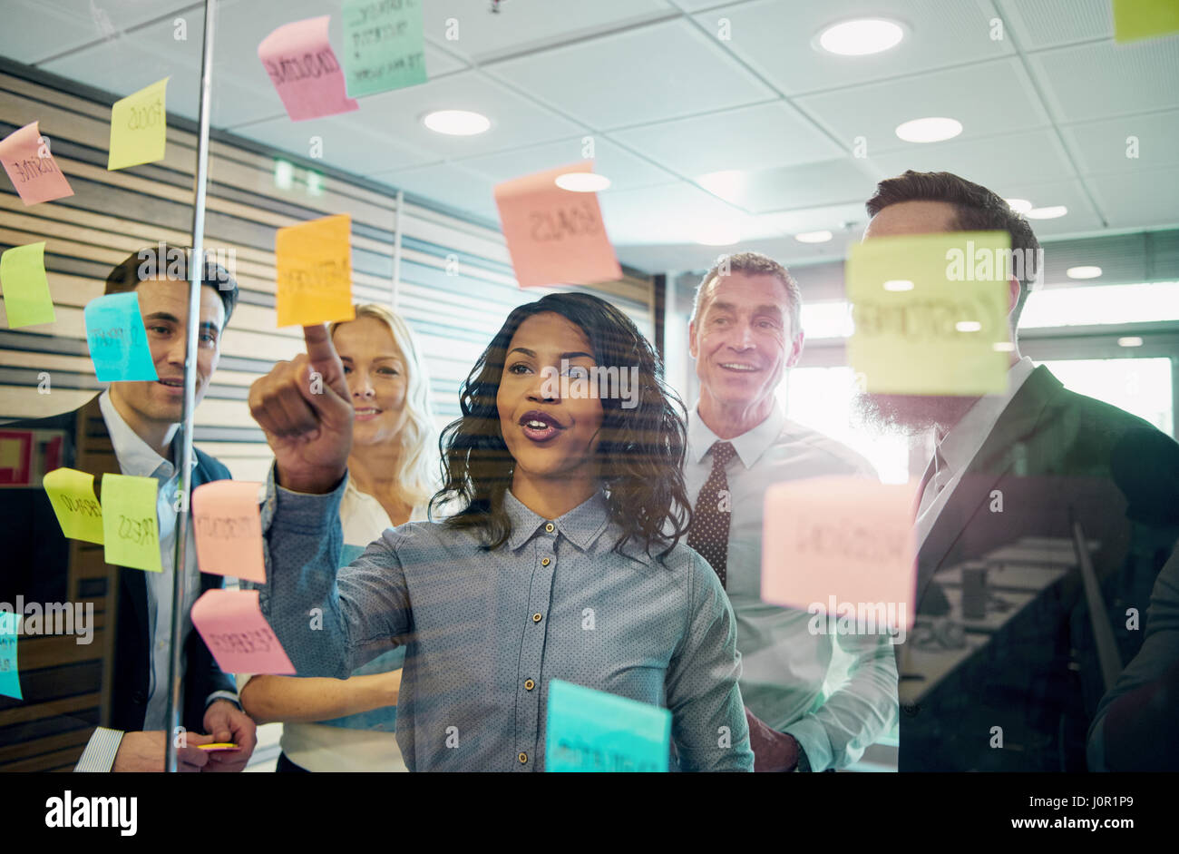 Business people in office cooperating at the wall with the stickers ...