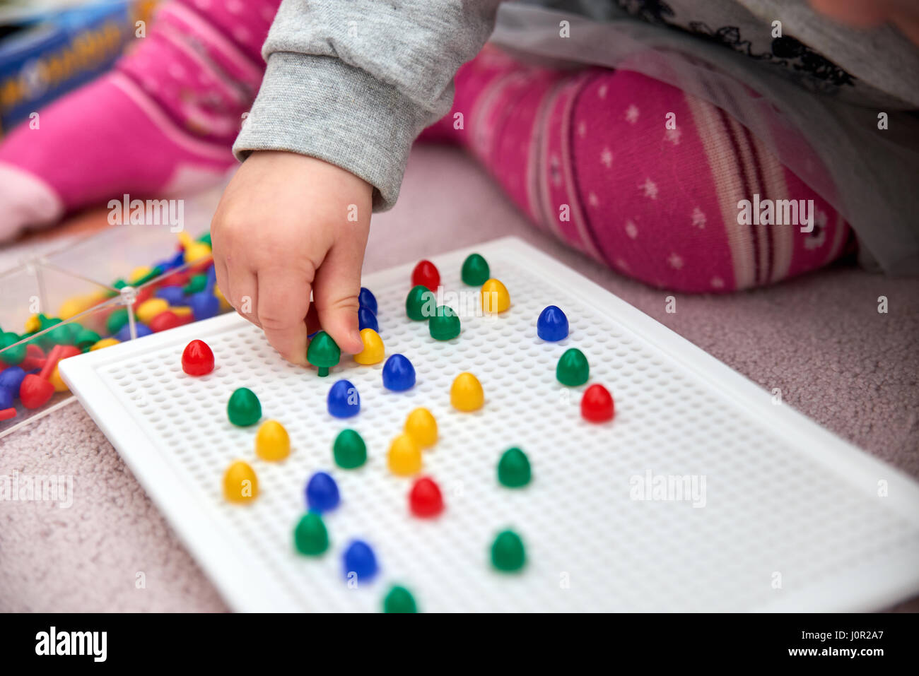 toddler plays with colorful pins Stock Photo - Alamy