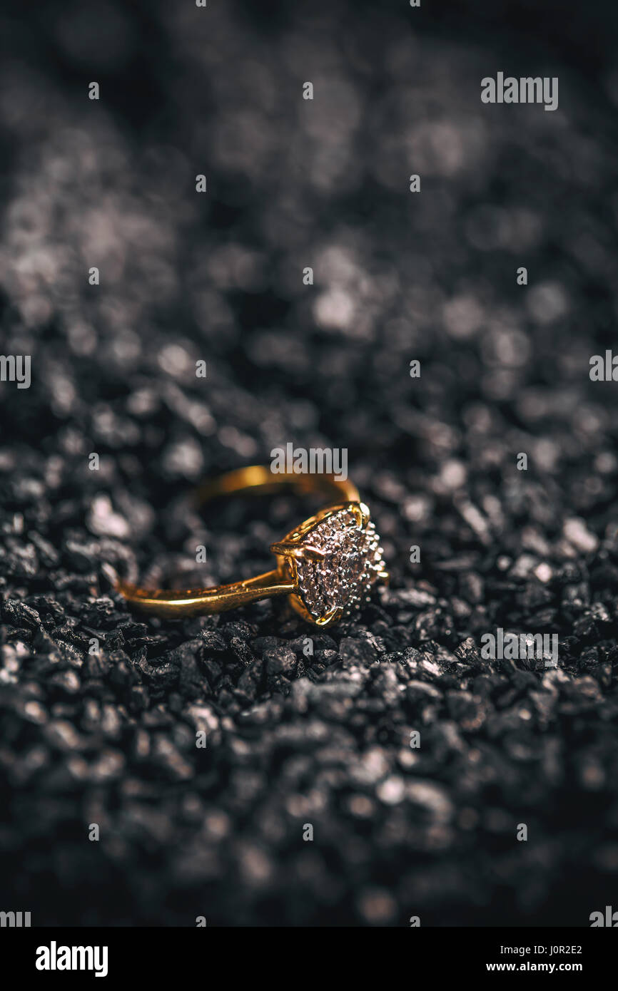 Gold engagement ring with diamonds on black background Stock Photo - Alamy