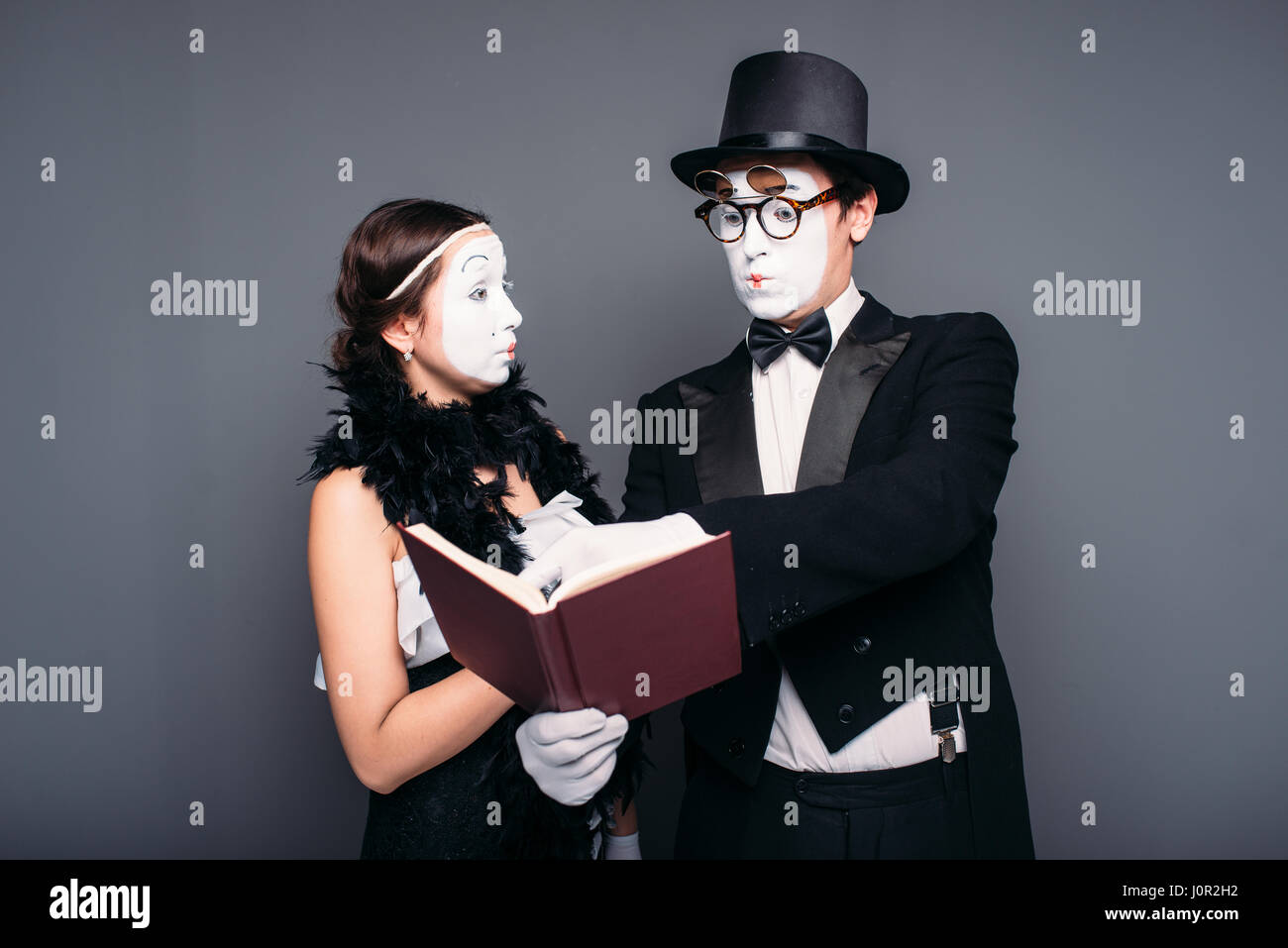 Two pantomime theater performers posing with book. Mime actor and ...