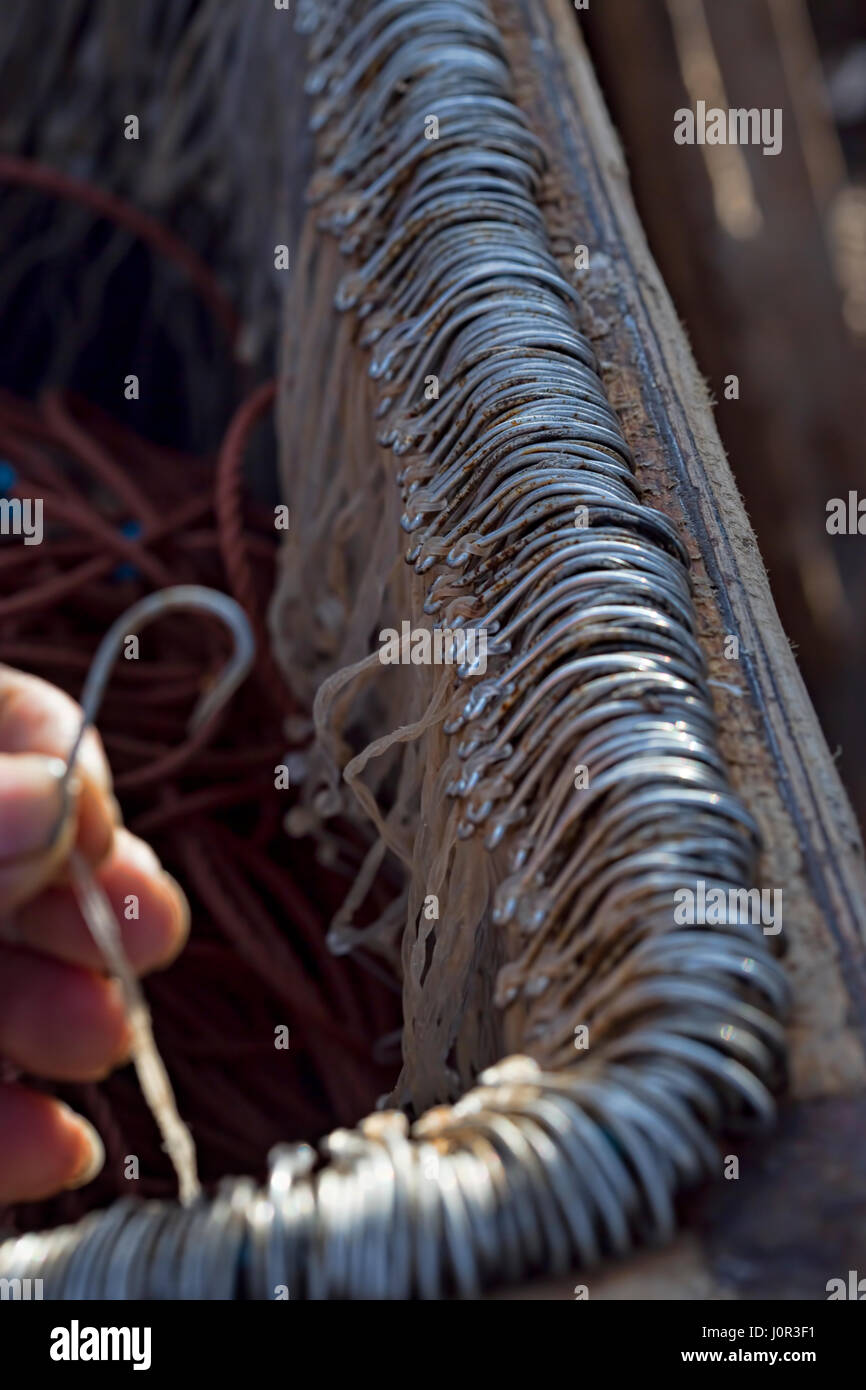 Fisherman placing hook in the box with fishing hooks Stock Photo - Alamy