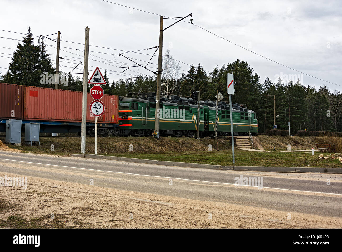 Railroad crossing the locomotive of freight train Stock Photo - Alamy