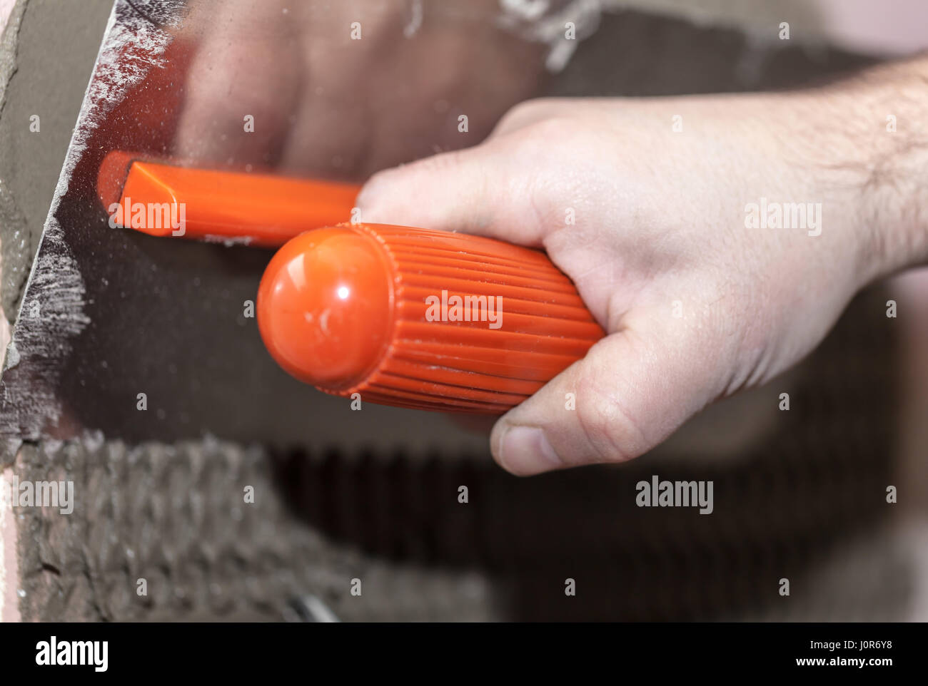 repair work laying tile, trowel in a man hand Stock Photo - Alamy