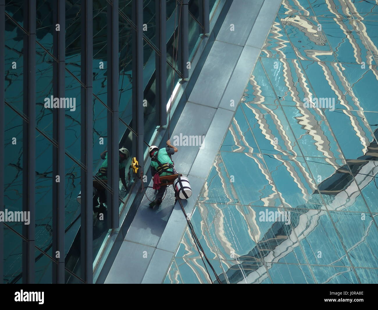 man cleaning slope glass building Stock Photo - Alamy