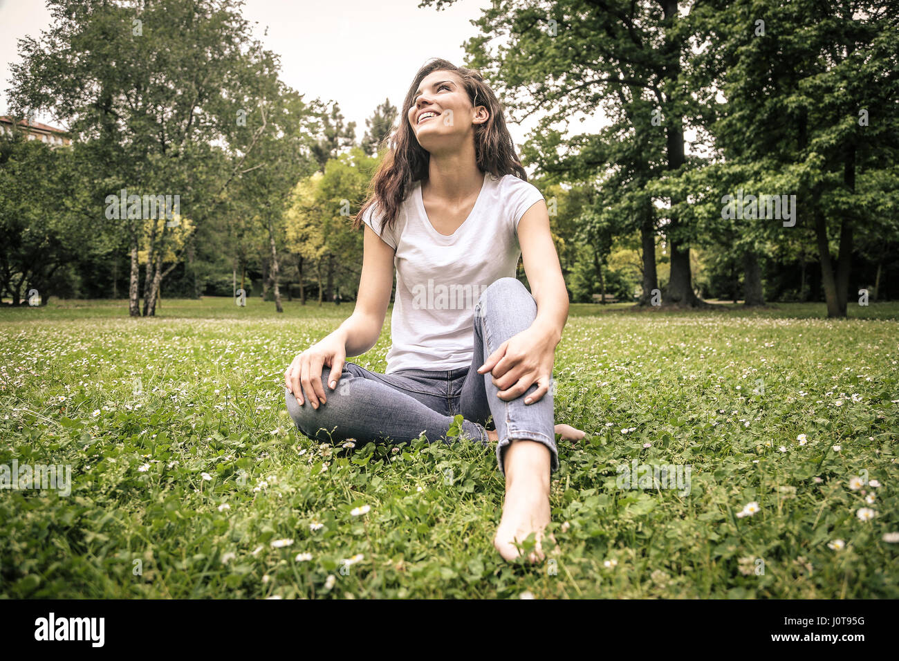 Brunette woman sitting in the nature Stock Photo - Alamy